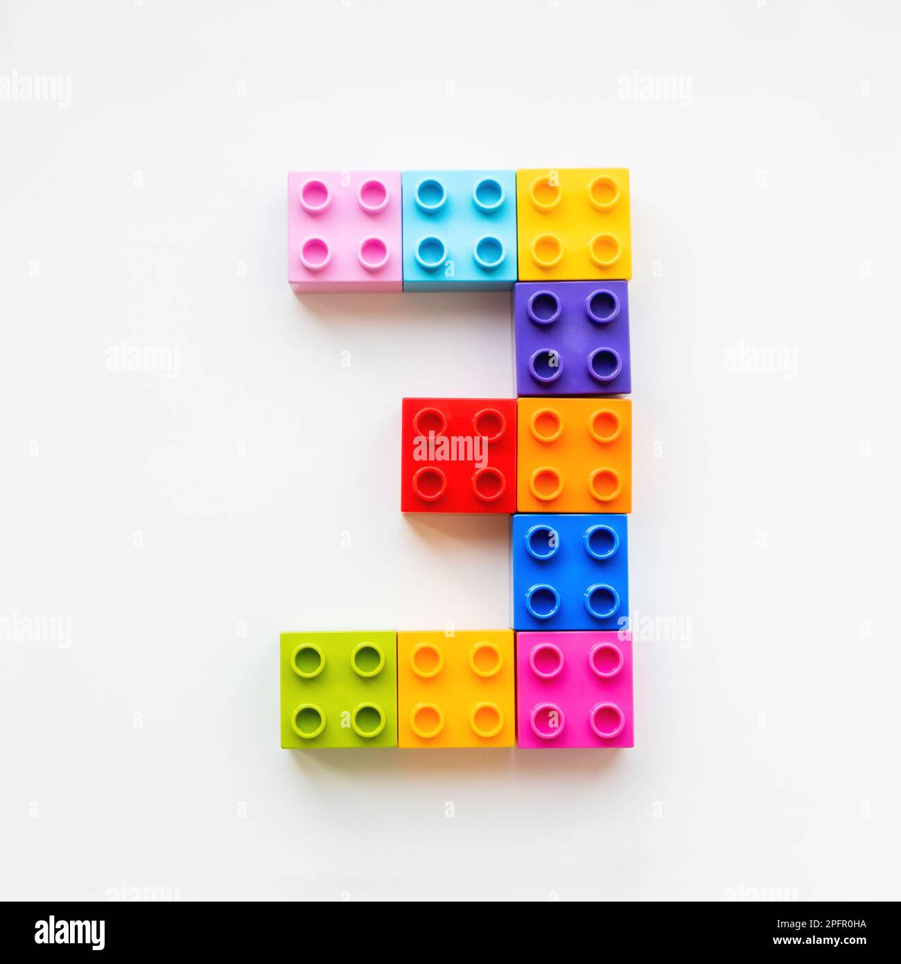 Number Three made of colorful constructor blocks. Toy bricks lying in ...