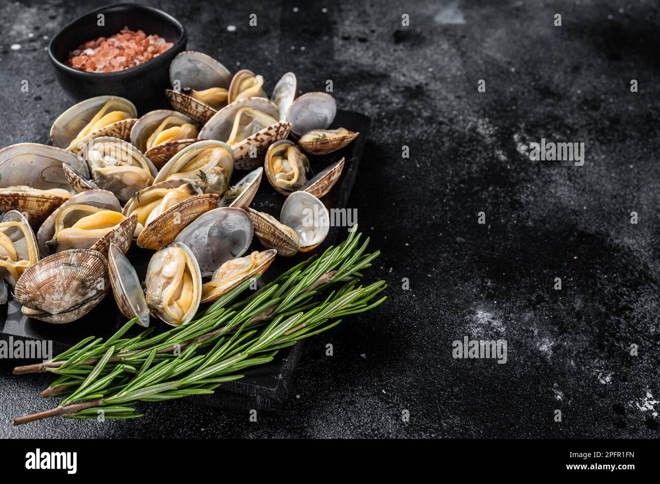 Steamed shellfish Clams with garlic and herbs. Black background. Top ...