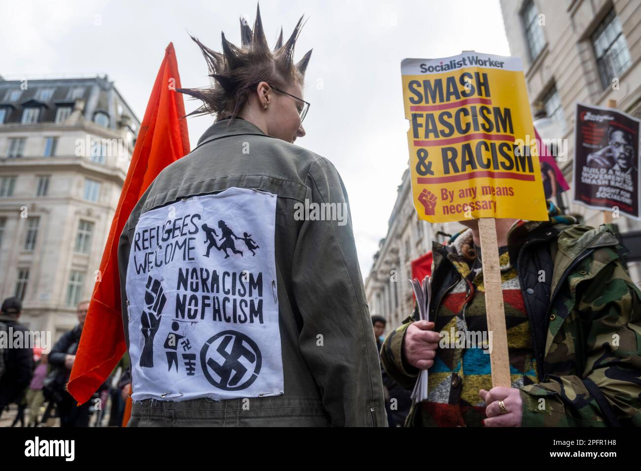 London, UK. 18 March 2023. A woman with a punk hair style takes part in ...