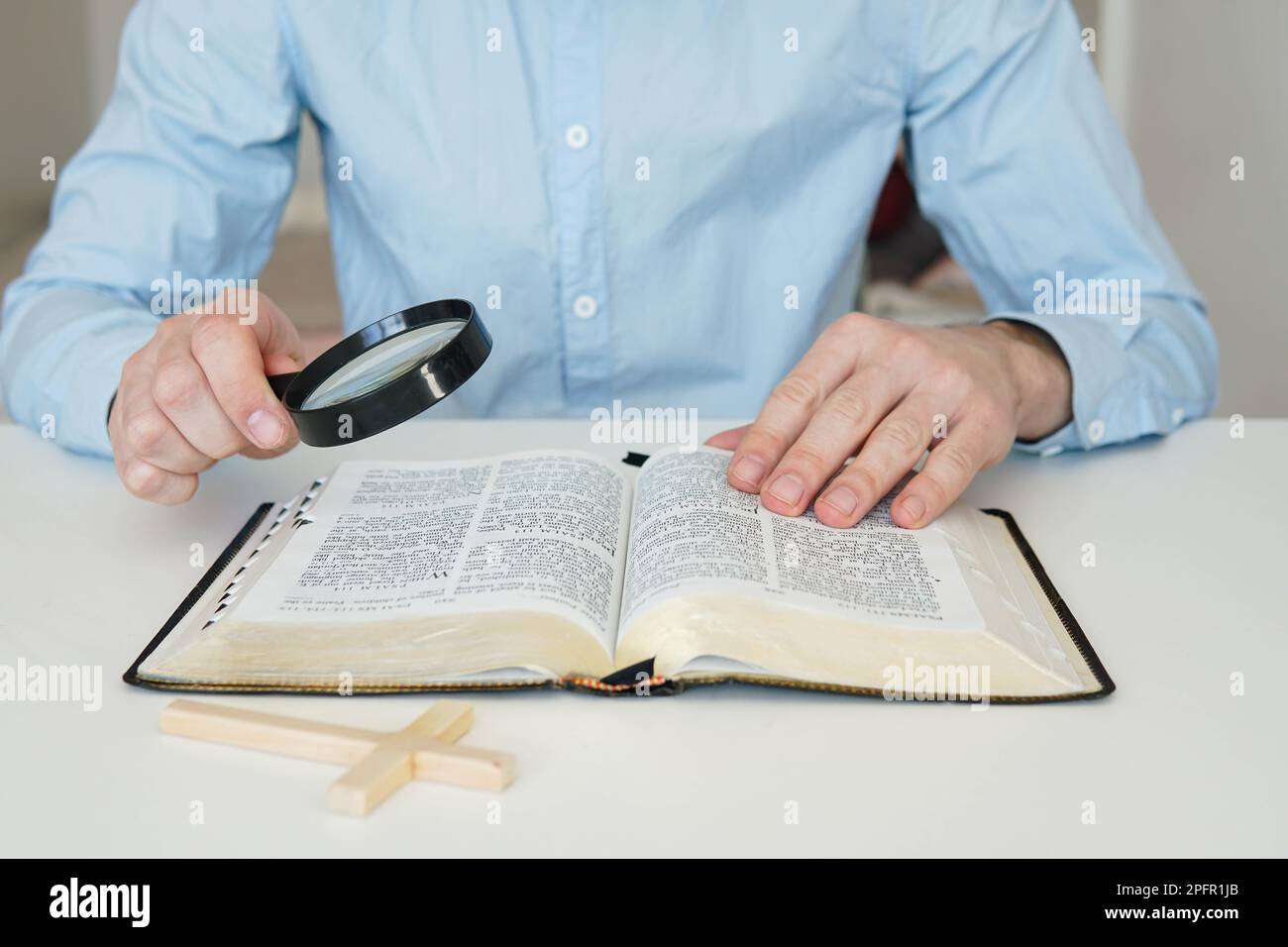Christian catholic man with magnifying glass searching for answers in ...
