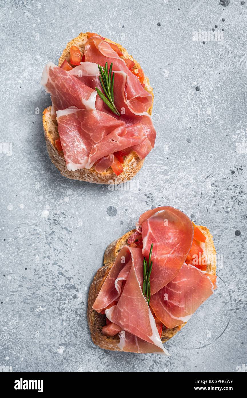 Spanish Tapas with tomatoes and cured Slices of jamon iberico ham ...
