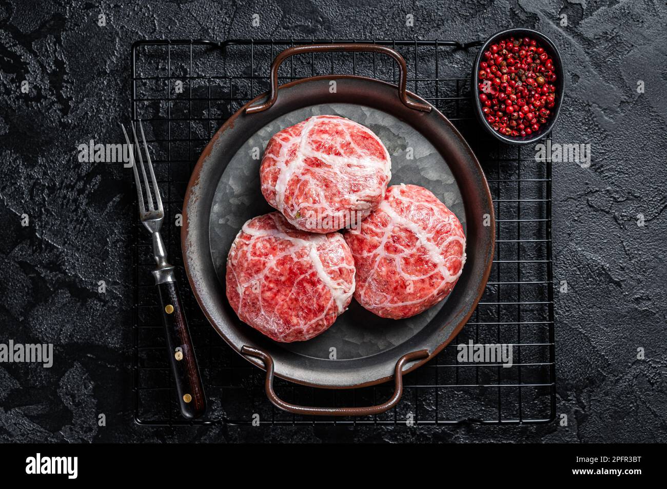 Raw pork cutlet, Crepinette with spices and herbs. Black background ...
