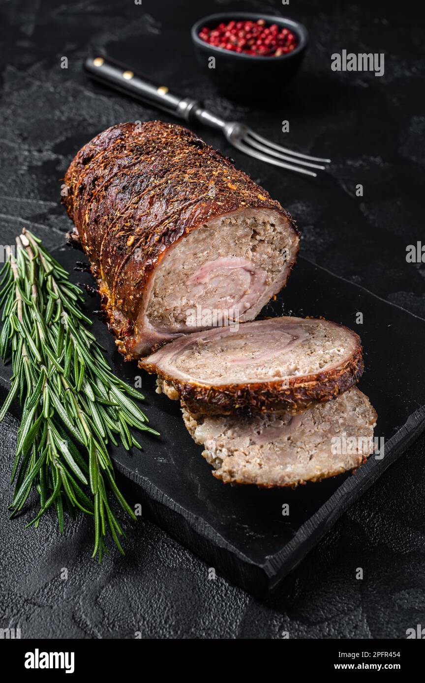 Baked pork roulade Porchetta, rolled pork meat on a marble board with ...