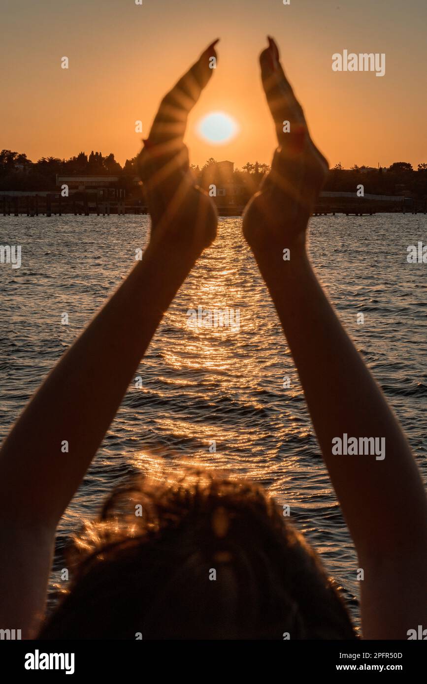 Silhouette against the sunset - hands folded in the shape of a heart ...