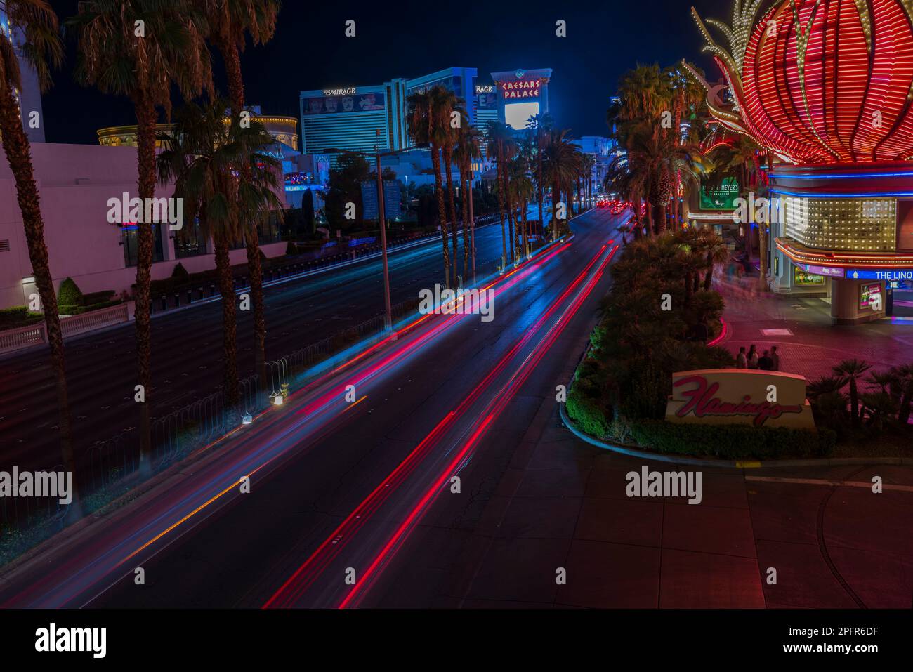 View of out-of-focus strip road tracers. Night view of Las Vegas cityscape with defocused light ...