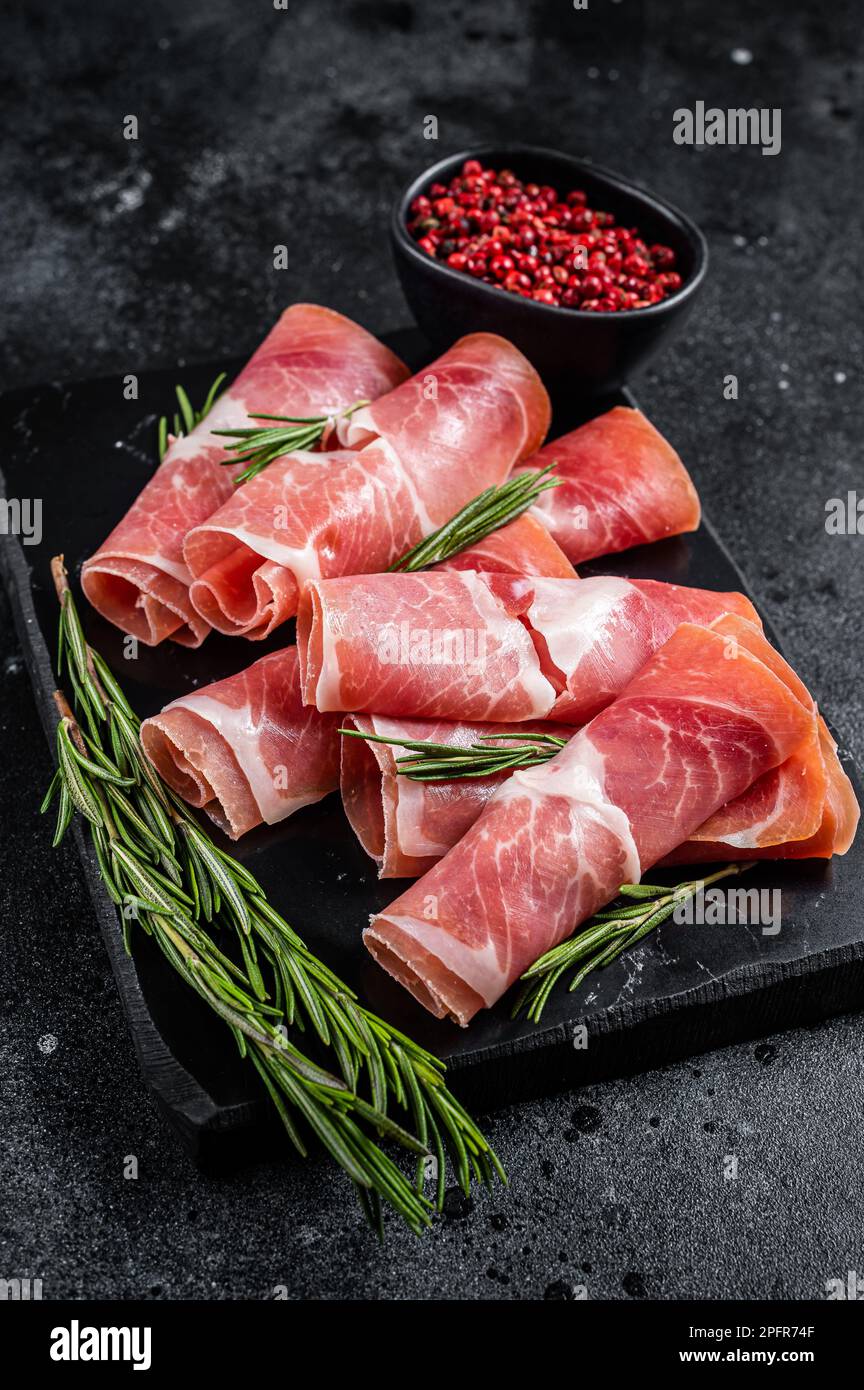 Traditional Spanish Jamon Serrano ham on marble board. Black background ...