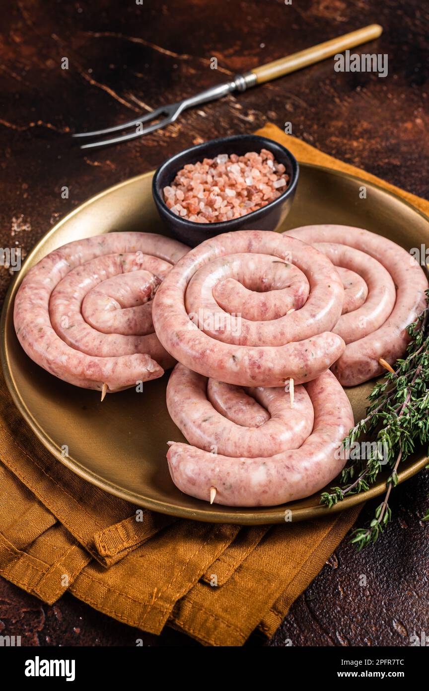 Raw spiral pork sausages, uncooked Wurst. Dark background. Top view ...
