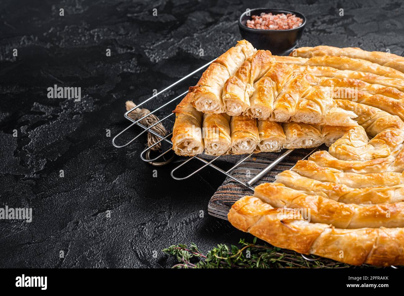 Turkish Tepsi Boregi, Round Borek cheese pie on kitchen board. Black ...