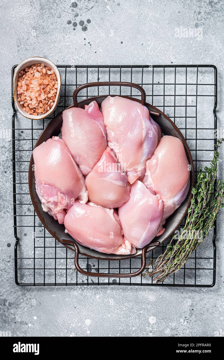 Boneless and skinless Raw Chicken leg thigh fillet. Gray background ...