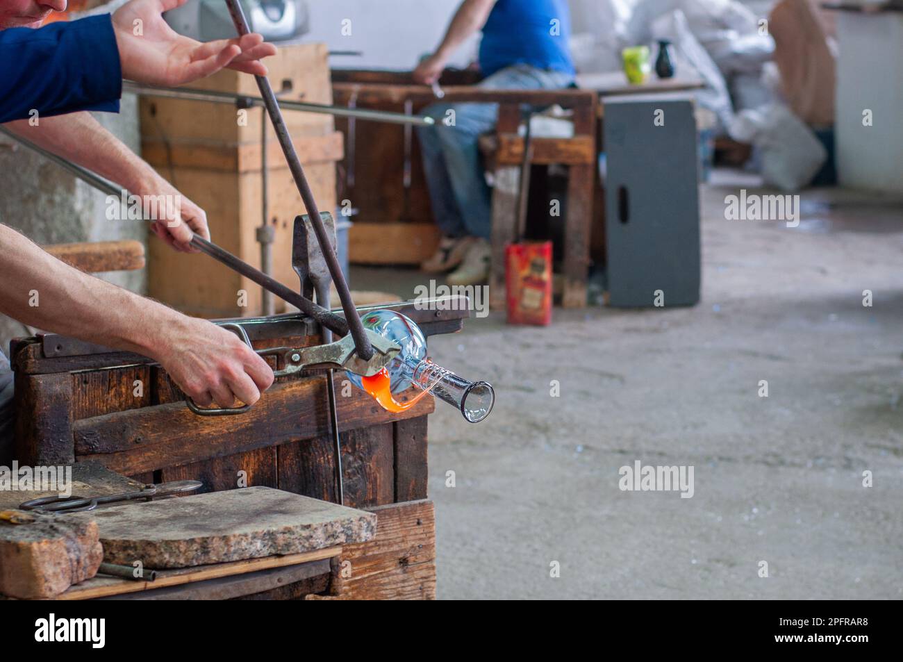 Traditional glassblowing worker shaping liquid glass Stock Photo - Alamy