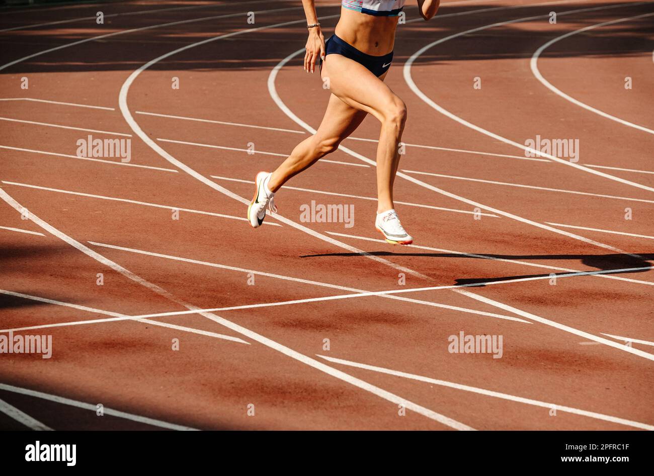 legs female athlete running race at stadium, spikes shoes for running ...