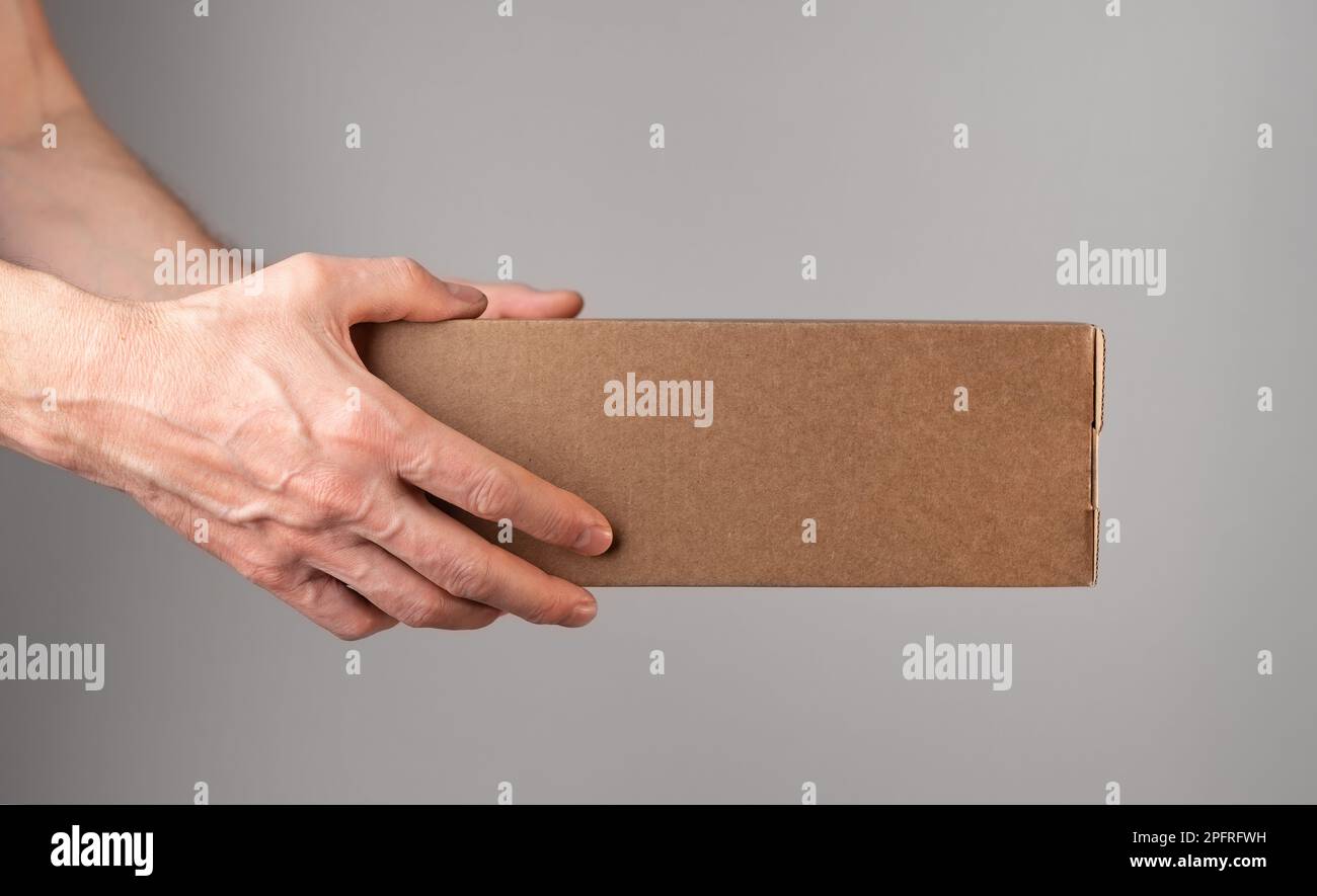 Hand holding cardboard box, parcel, order package, closed pack Stock Photo - Alamy