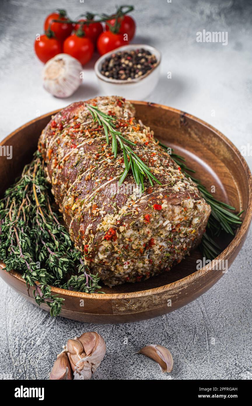 Raw italian Porchetta seasoned with herbs, pork meat roll. White ...