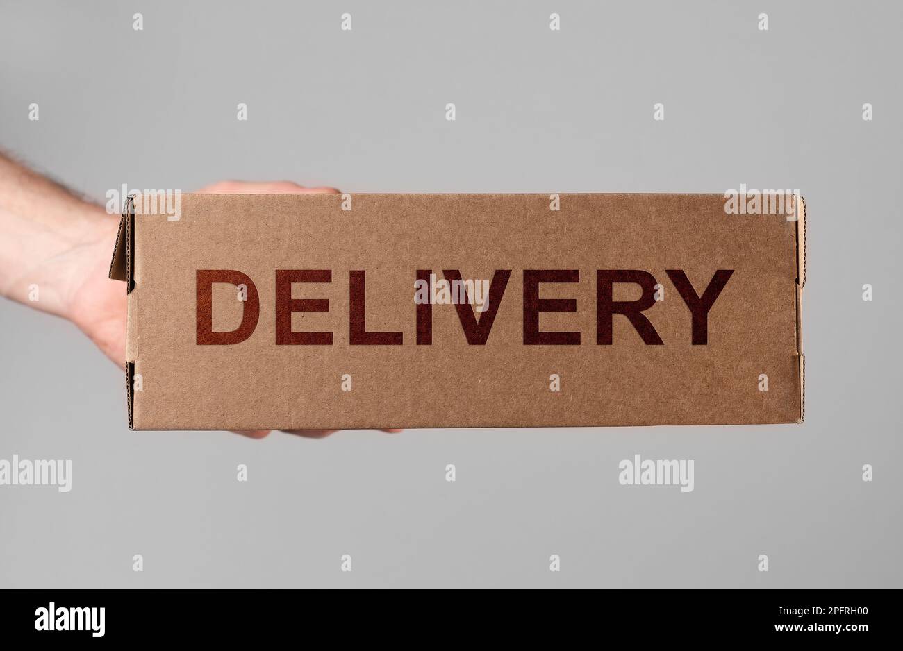 Couriers hands delivering cardboard box, order, parcel in brown carton ...