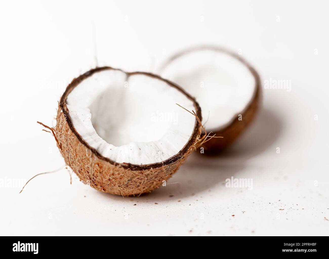 Open coconut halves. Two parts pieces of coco nut fruit with brown ...