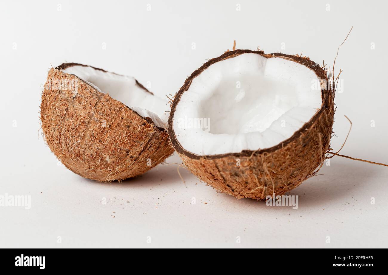 Open coconut. Two halves, cut pieces of coco nut with brown shell and ...