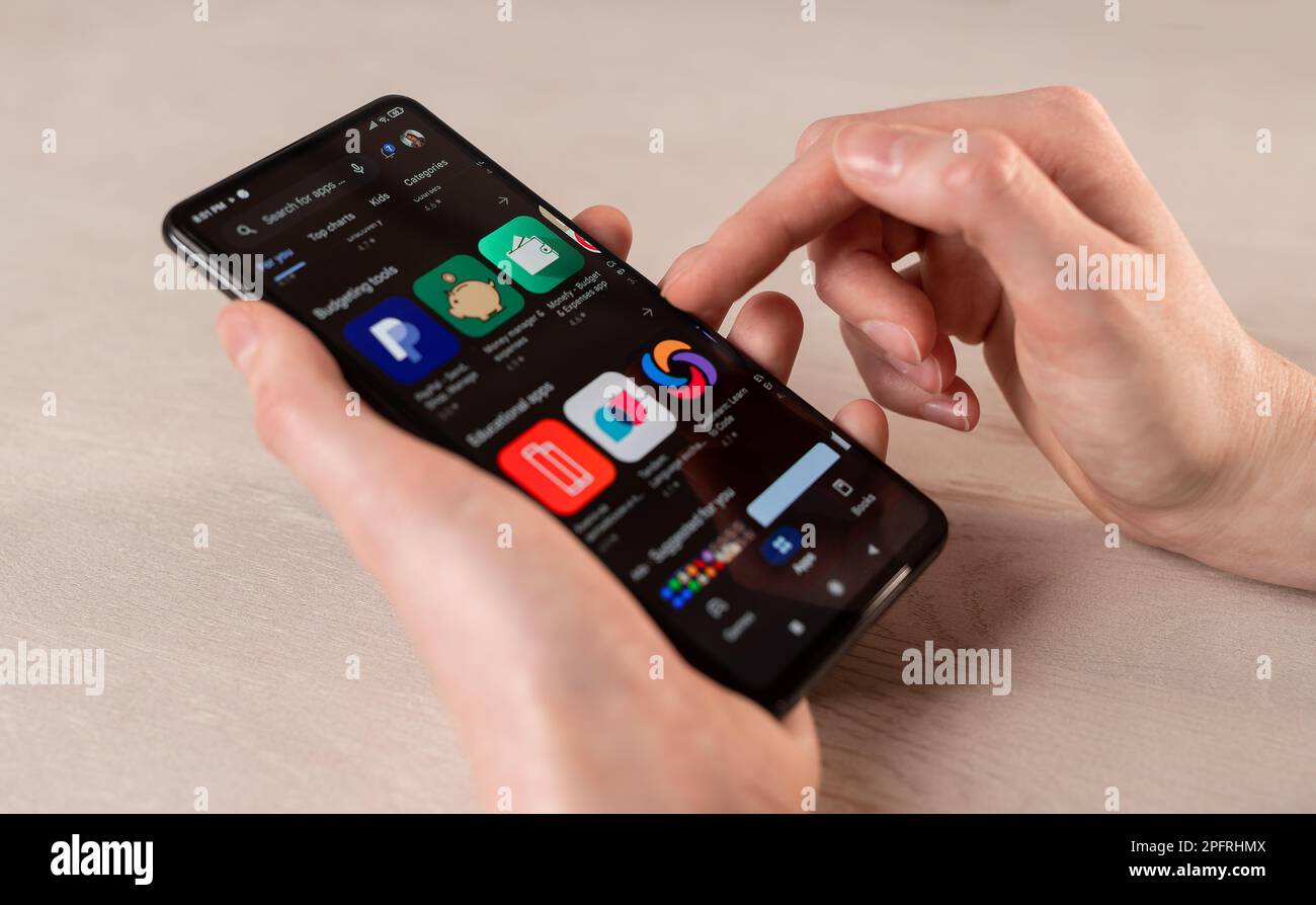 Lodz, Poland February 07 2023 Hands using mobile phone, choosing ...