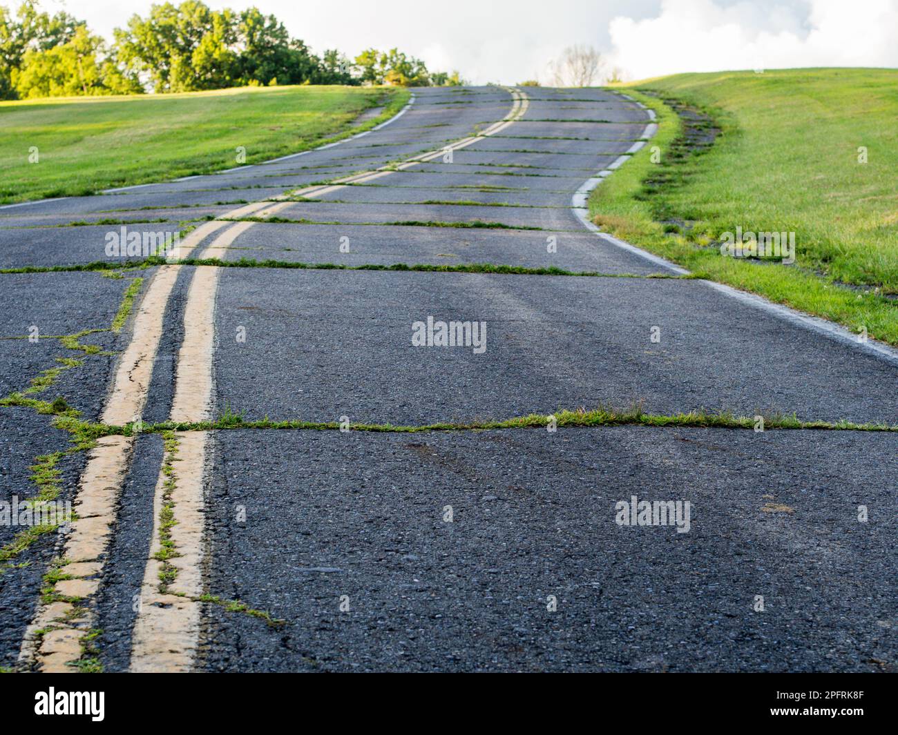 Worn road with double road markings overgrown with grass Stock Photo ...
