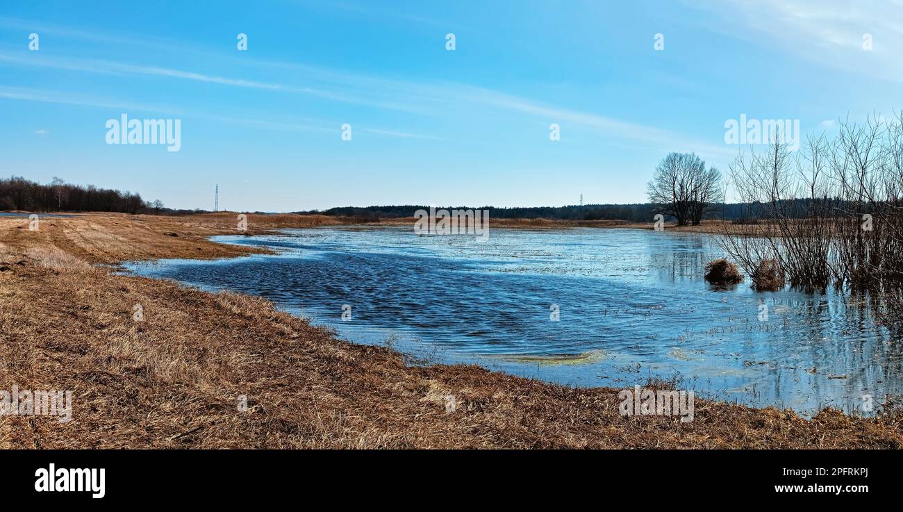 Early spring, river flood on agricultural meadows. Reflection in ...