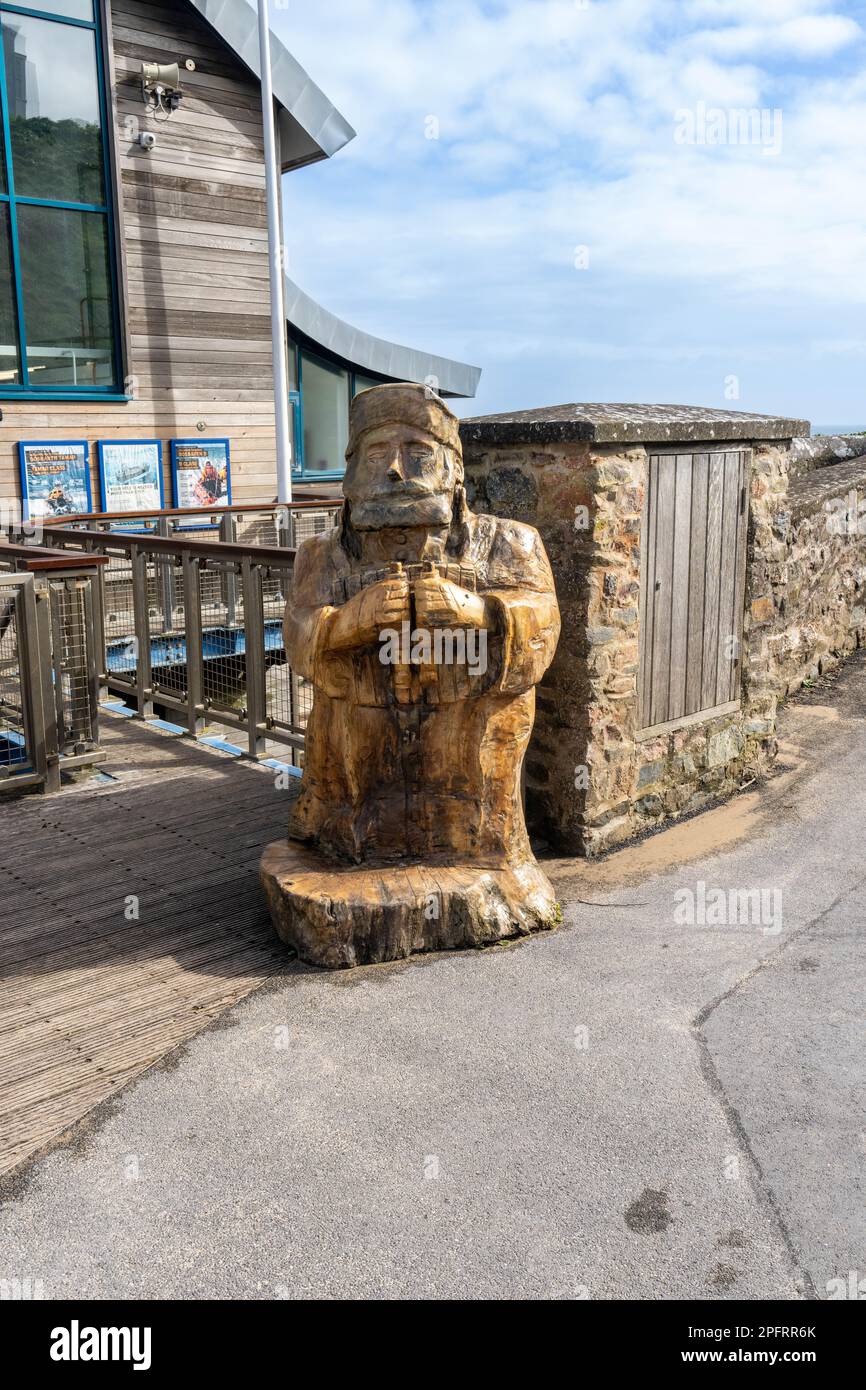 Wooden sculpture of a lifeboatman outside lifeboat house in Tenby Stock ...