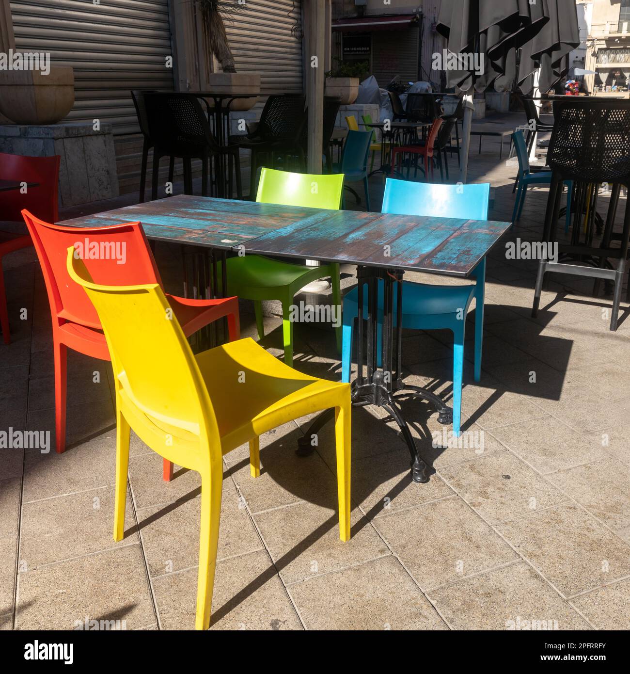 Restaurant zone with colorful plastic chairs and tables and yellow ...