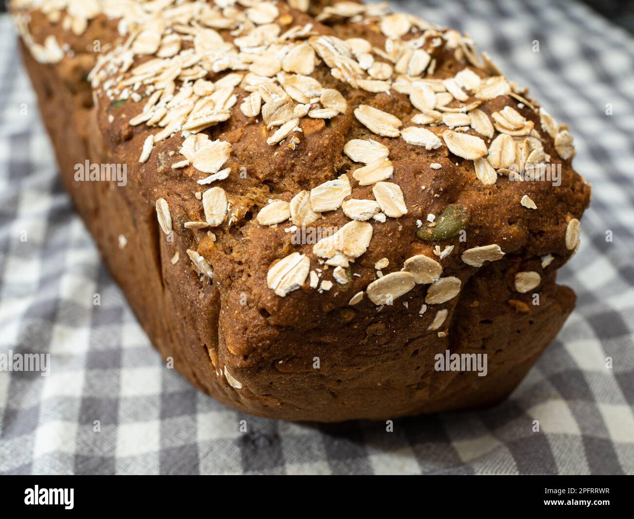 Home made baked bread with oats on top on a checkered linen cloth Stock ...