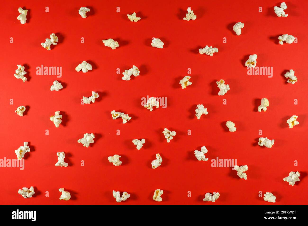 Texture of salted popcorn on a red background. Top view of popcorn ...