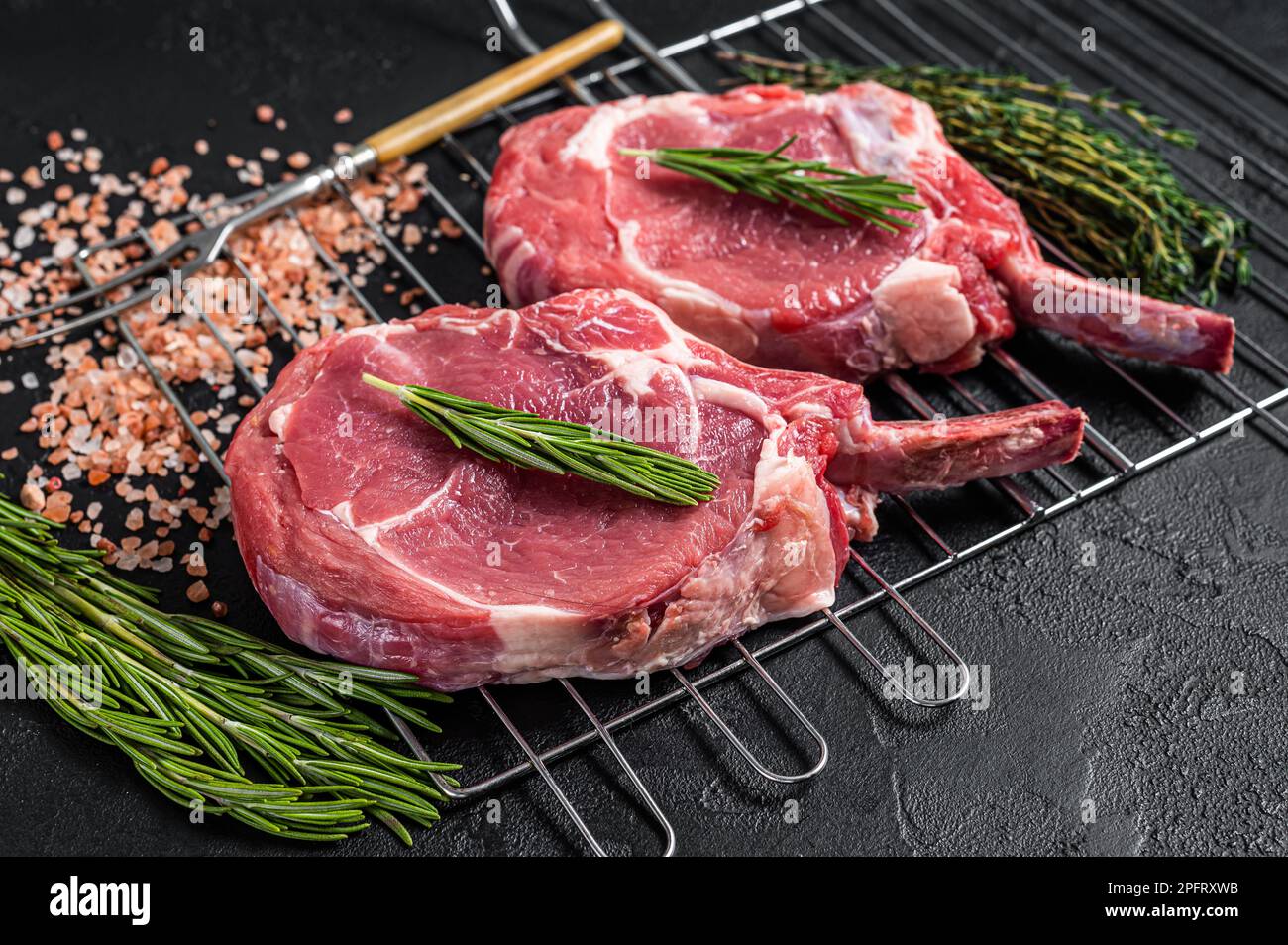 Fresh Raw Tomahawk rib eye beef steaks on grill. Black background. Top ...