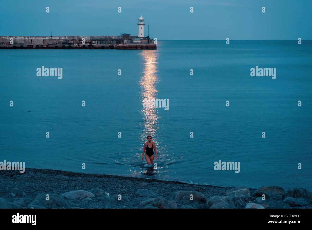 Woman The full moon rises to the lighthouse, the lunar path along the ...