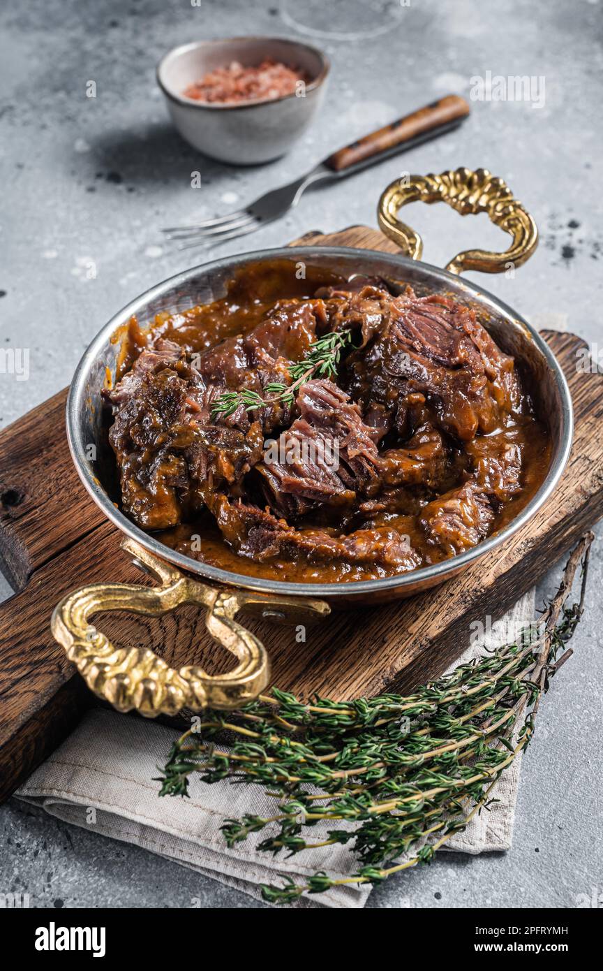 German braised beef cheeks in brown red wine sauce. Gray background ...