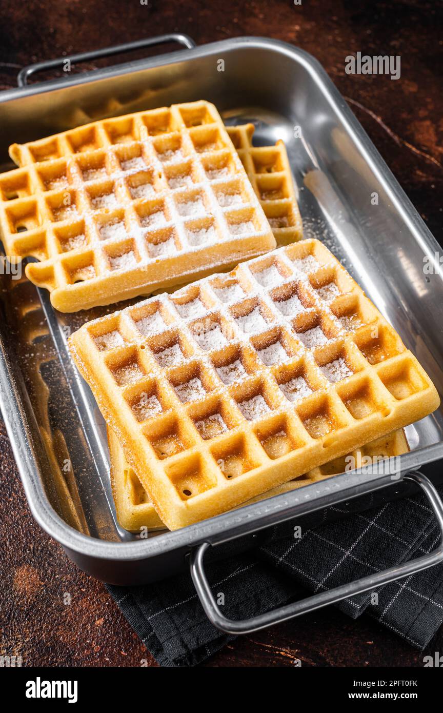 Viennese waffles with powdered sugar in kitchen steel tray. Dark ...