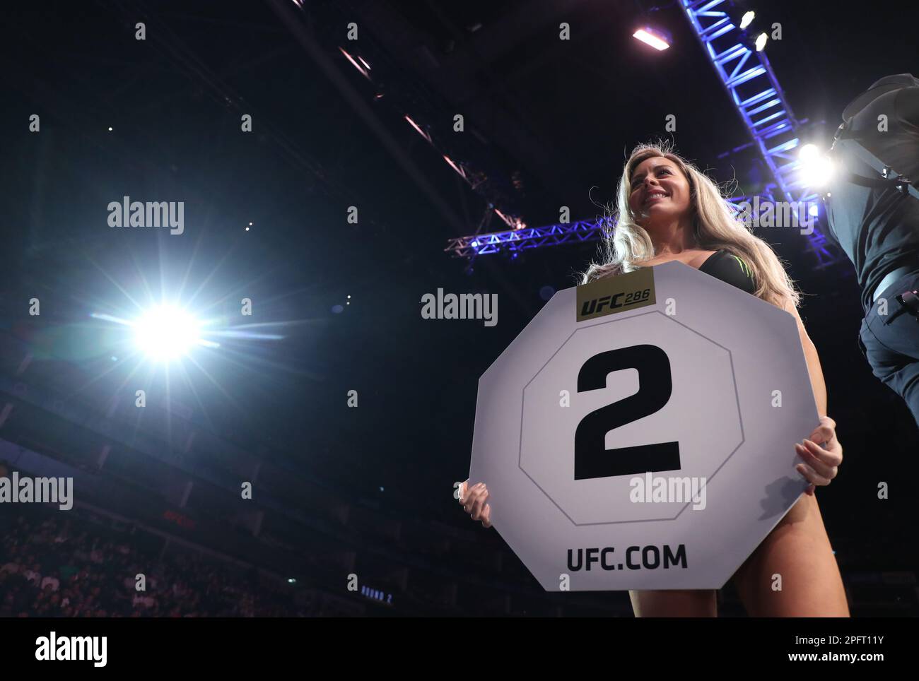 A ring girl holds up a UFC round number sign during UFC 286 at 02 Arena ...