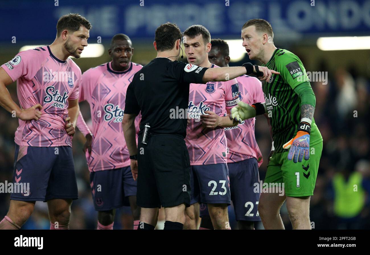 Everton players surround referee Darren England after a penalty is ...