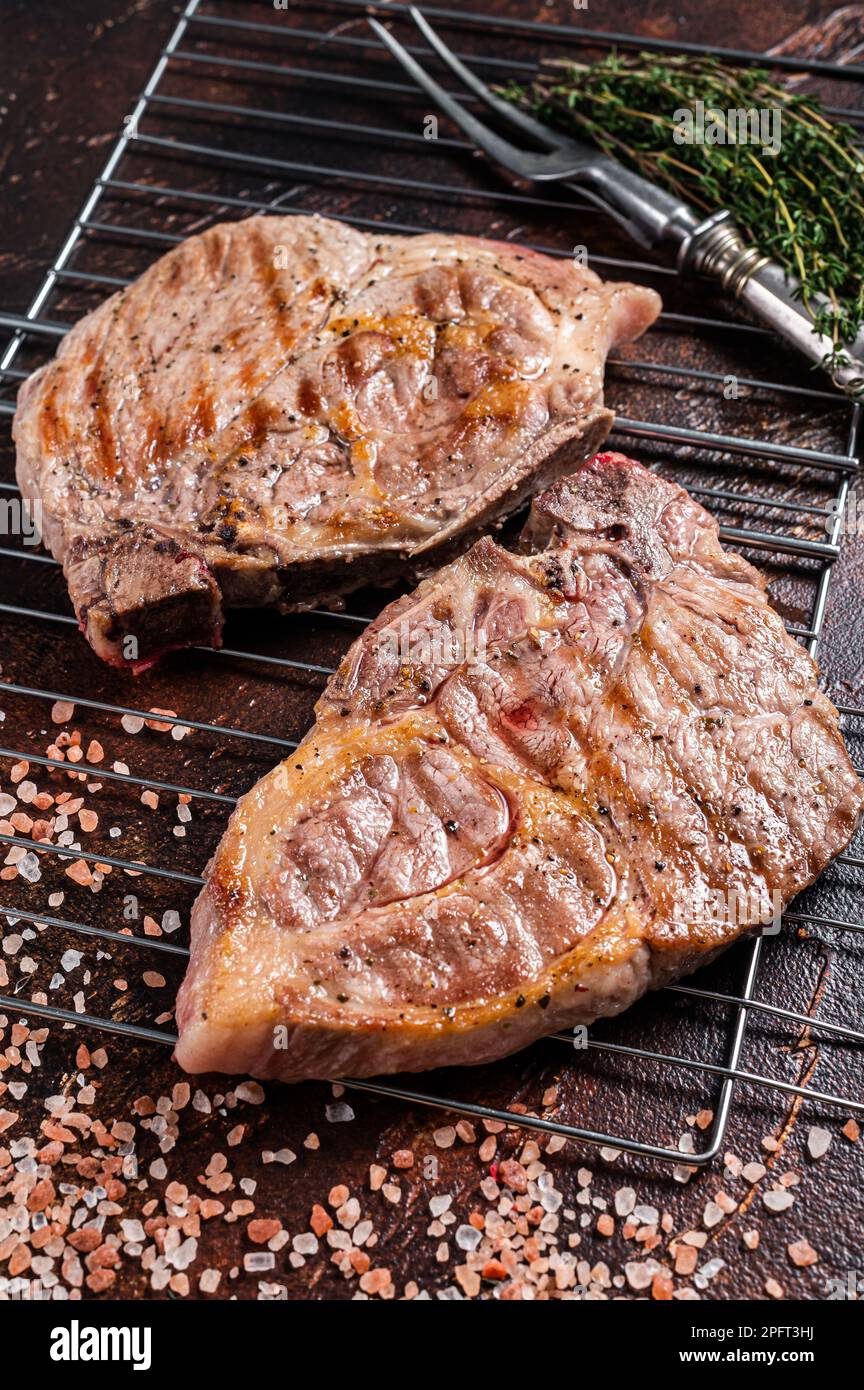 BBQ Grilled Pork loin steaks from neck fillet meat on grill. Dark ...