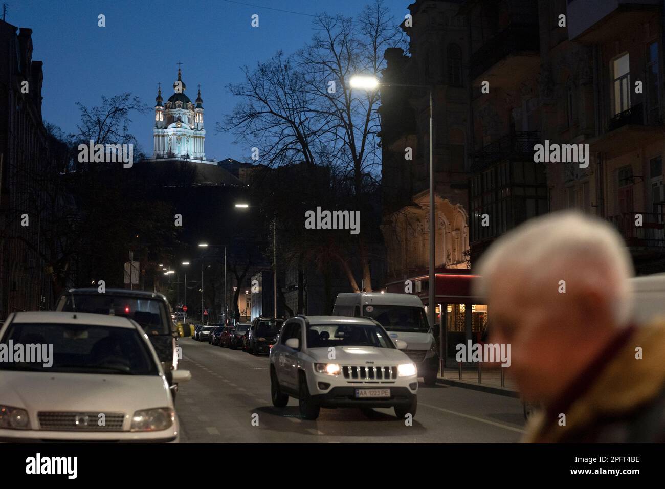 A man walks with the St. Andrew's Church on the background in Podil district in Kyiv, Ukraine ...