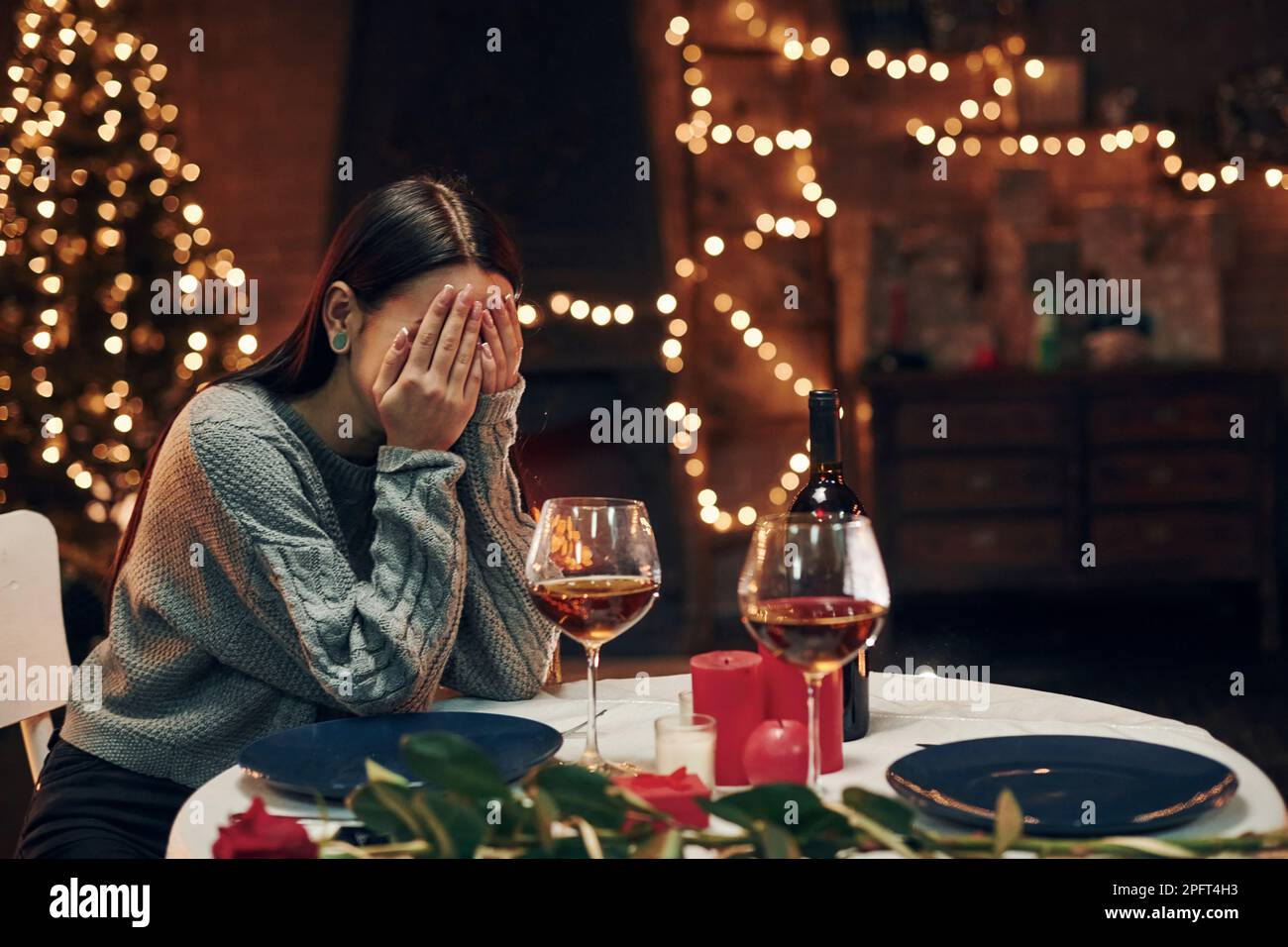 Sad young brunette sits by the table in restaurant and crying Stock ...