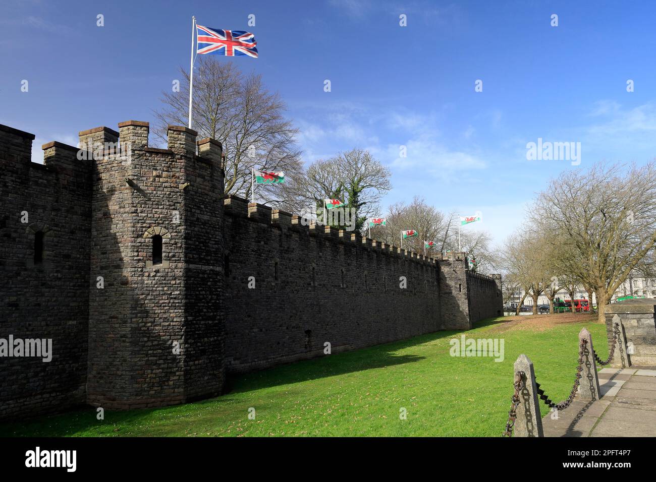 Outer wall of Cardiff Castle with union flag and Welsh Dragon flags ...
