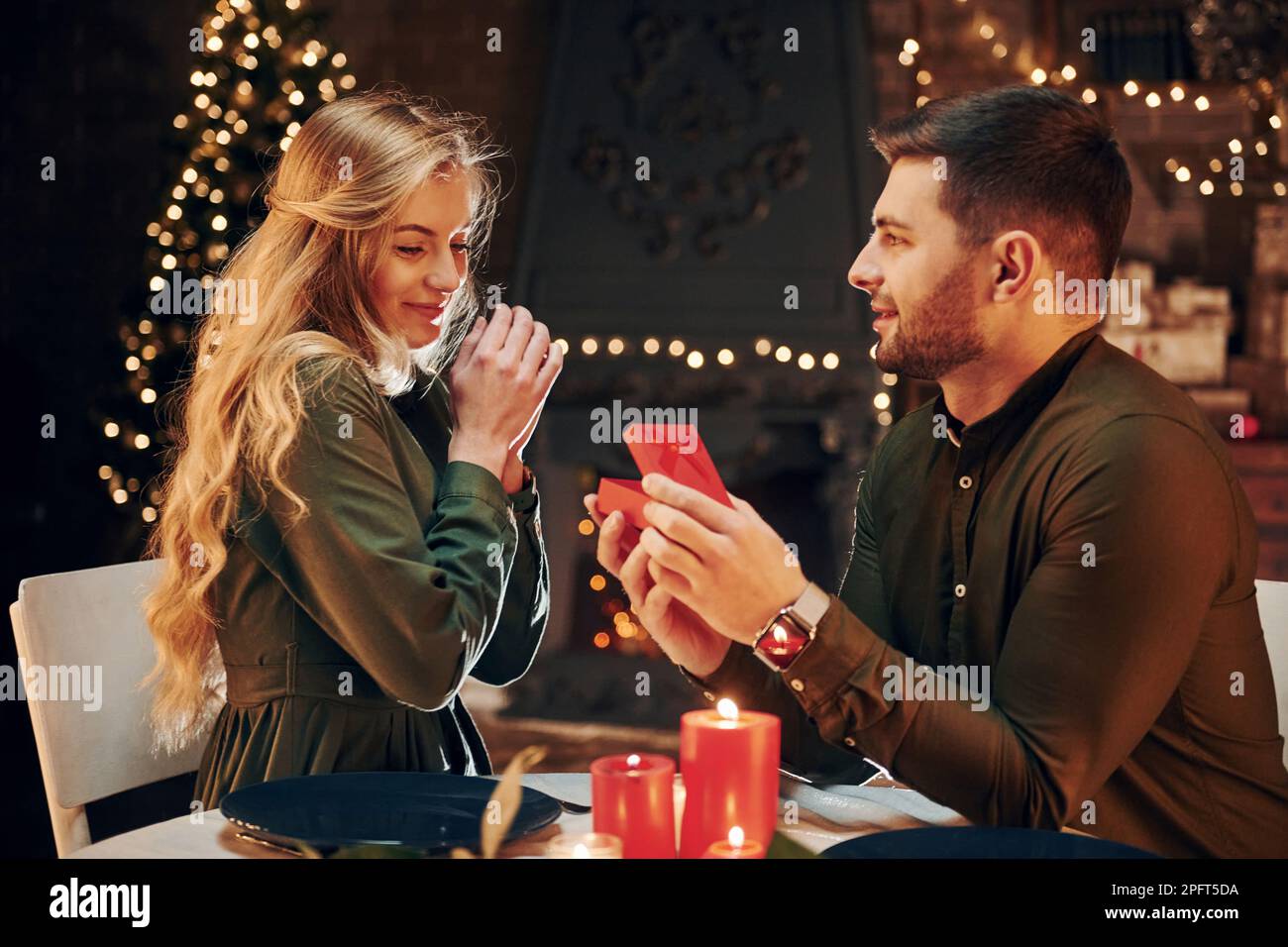 Man proposing a beautiful woman to marry him in an elegant restaurant ...