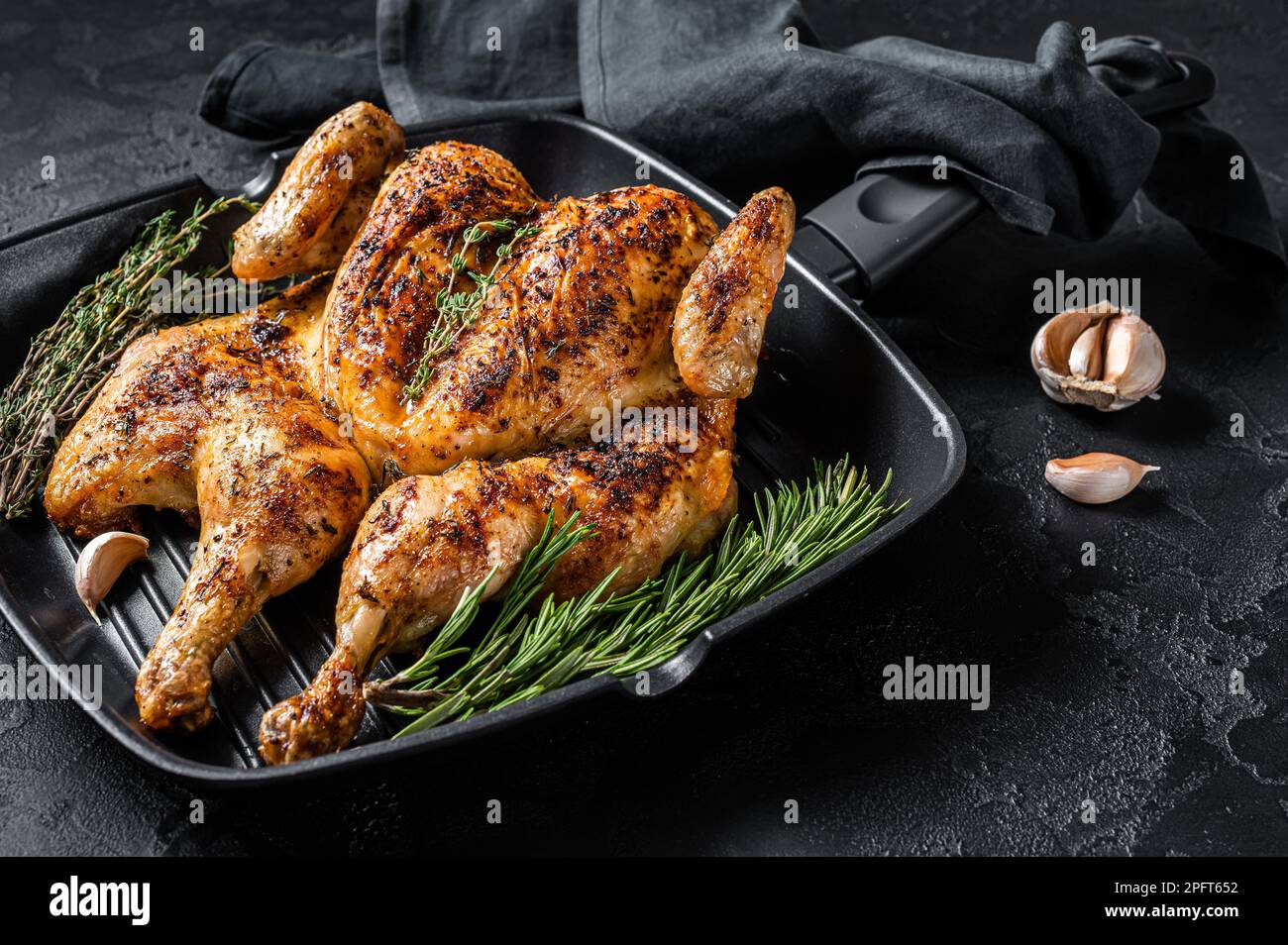 BBQ spatchcocked barbecue whole chicken on grill pan. Black background ...