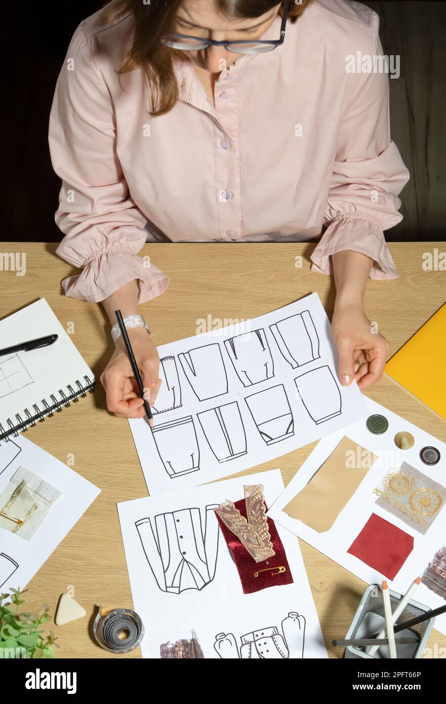 Woman fashion designer draws sketches of clothes on paper Stock Photo ...