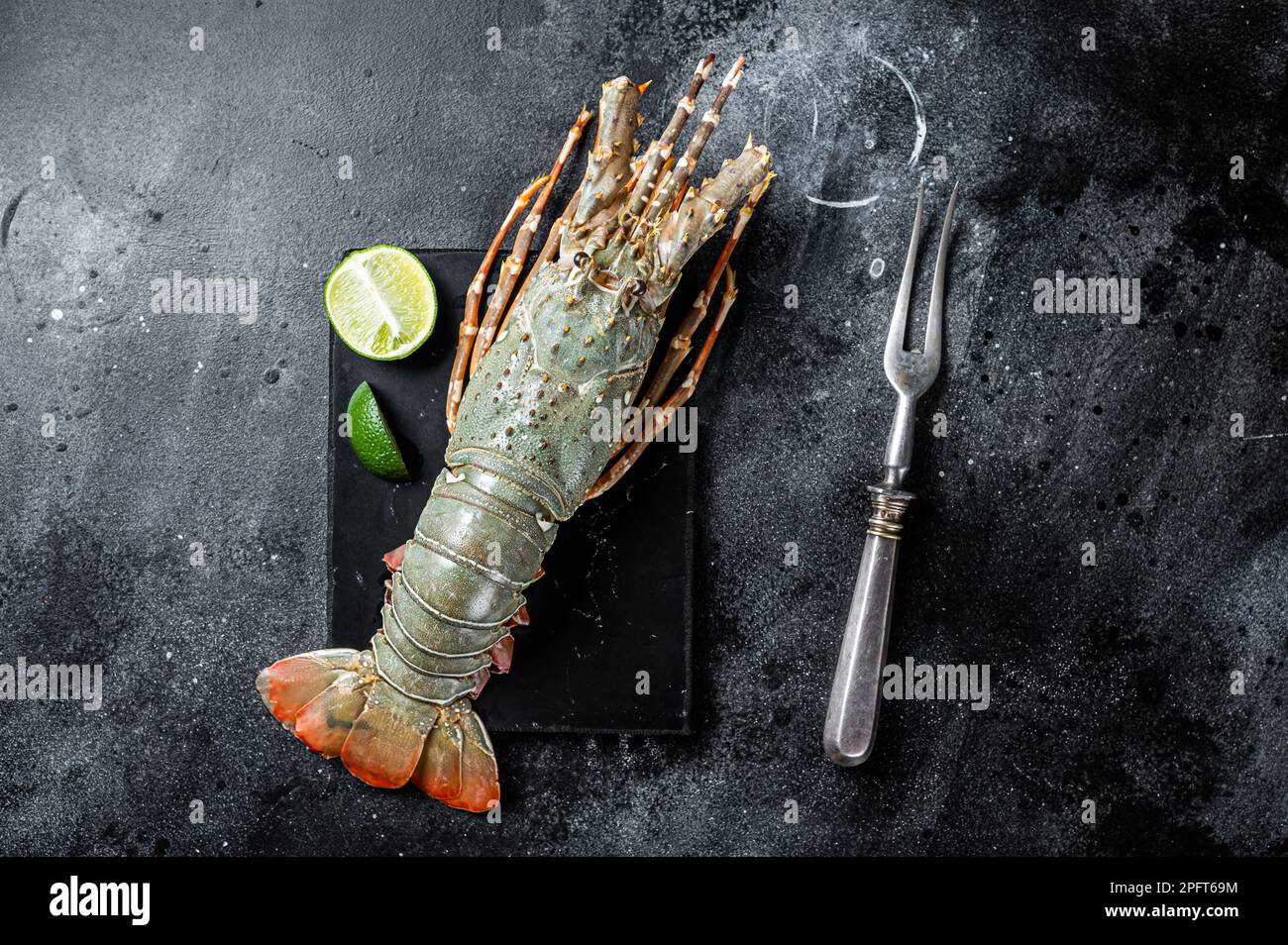 Raw Spiny lobster or sea crayfish on a marble board. Black background ...
