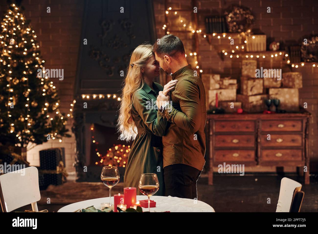 Standing and dancing. Young lovely couple have romantic dinner indoors ...