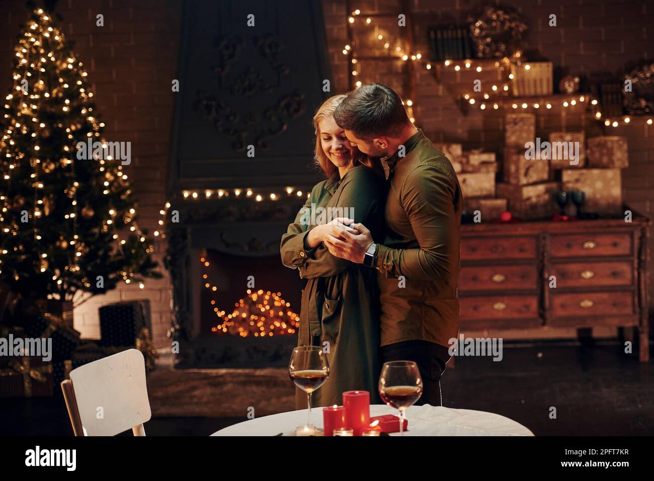 Standing and dancing. Young lovely couple have romantic dinner indoors ...