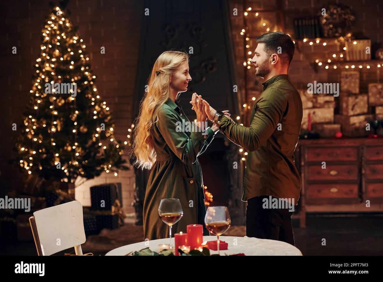 Standing and dancing. Young lovely couple have romantic dinner indoors ...