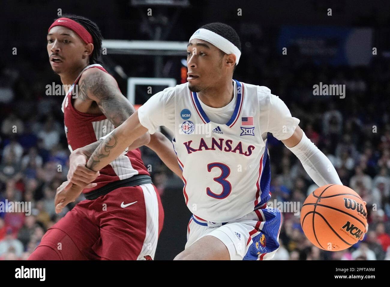 Kansas' Dajuan Harris Jr. drives by Arkansas' Nick Smith Jr. during the ...