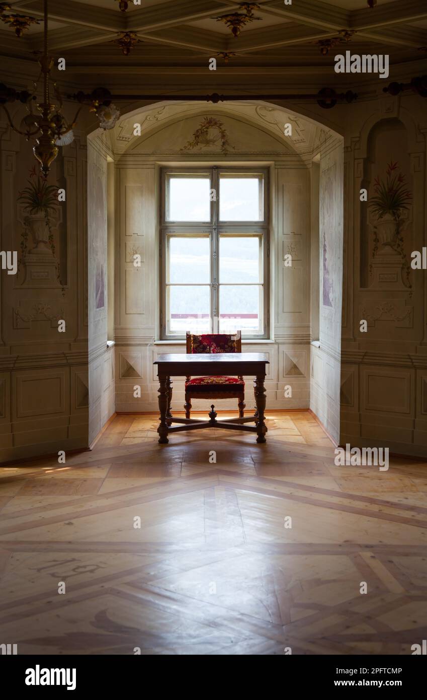 A solitaire chair and table in an ampty room of Castle Savoia, building ...
