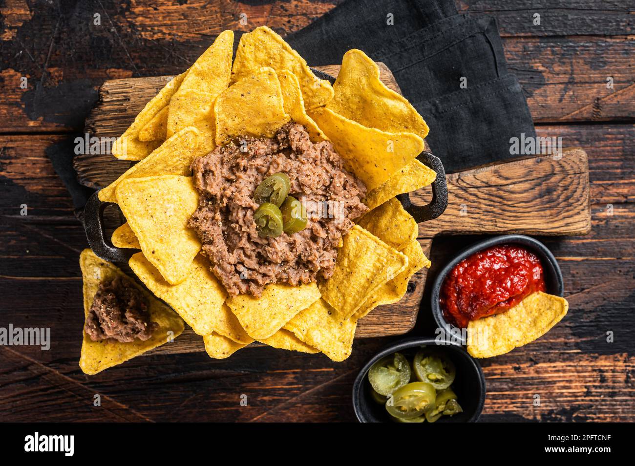 Mexican Baked nachos with chili con carne in a skillet. Wooden ...