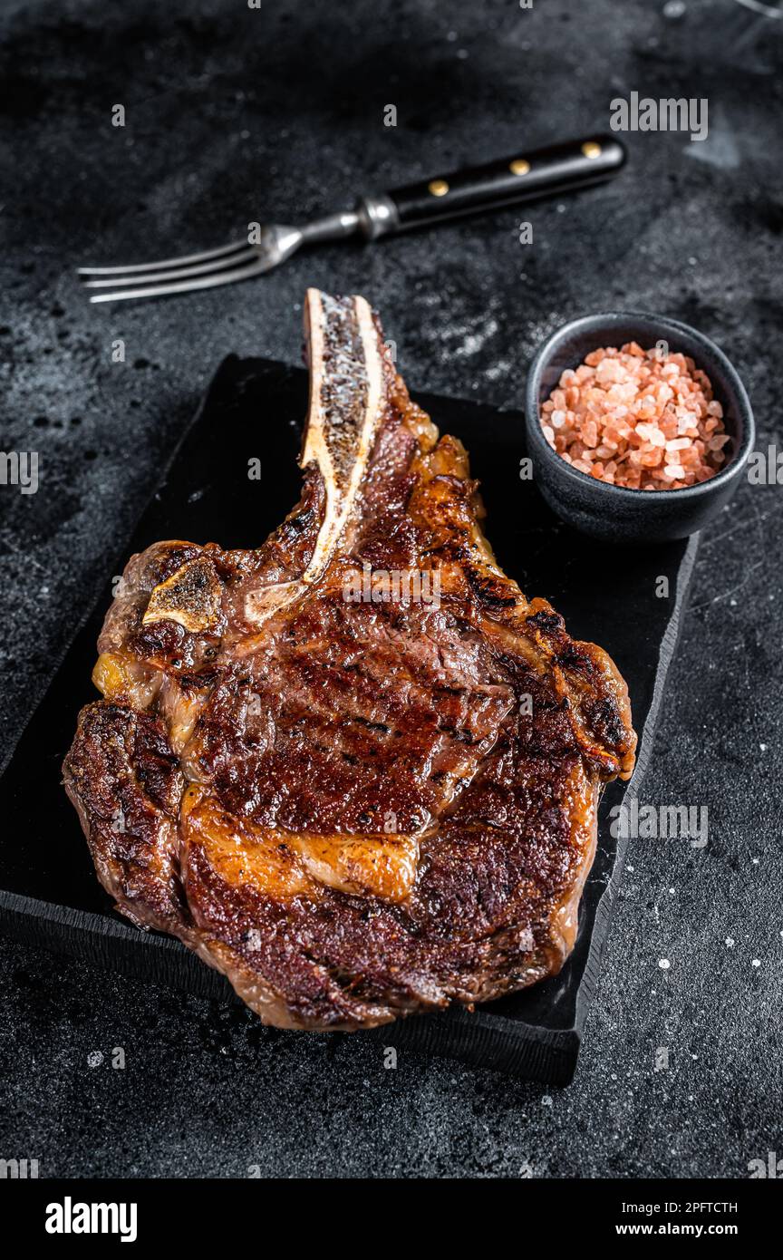 Grilled cowboy or rib eye with bone beef steak. Black background. Top ...