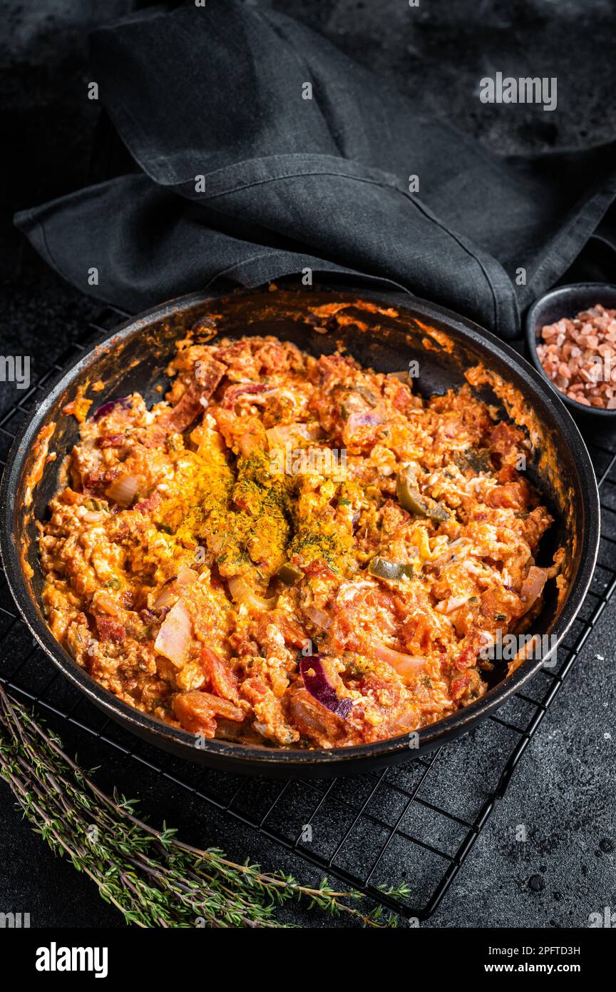 Turkish Menemen omelet in a frying pan. Black background. Top view ...
