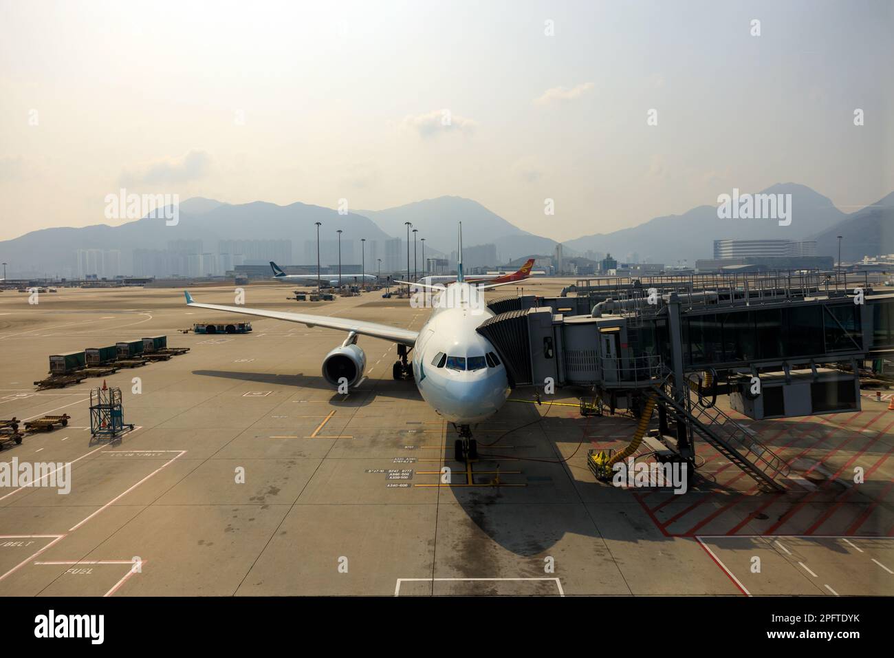 Hong Kong - March 1, 2023: Airplane at boarding gate jet bridge in Hong ... Hong Kong - March 1, 2023: Airplane at boarding gate jet bridge in Hong ...